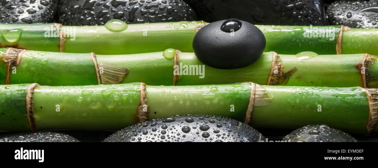 Black stone on bamboo Stock Photo - Alamy