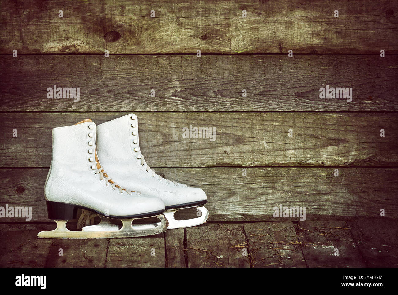 Old ice skates against rustic wooden background Stock Photo - Alamy