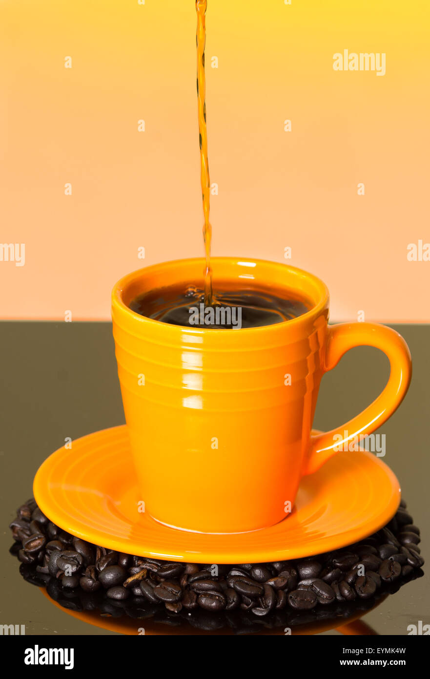 Great image showing stream of coffee pouring into orange cup from above ...