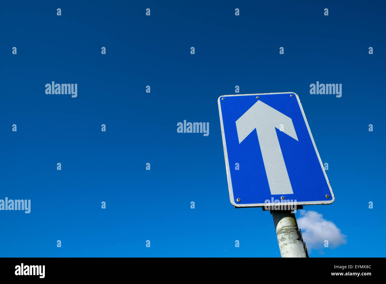 An arrow road sign against a blue sky with copy space UK Stock Photo ...