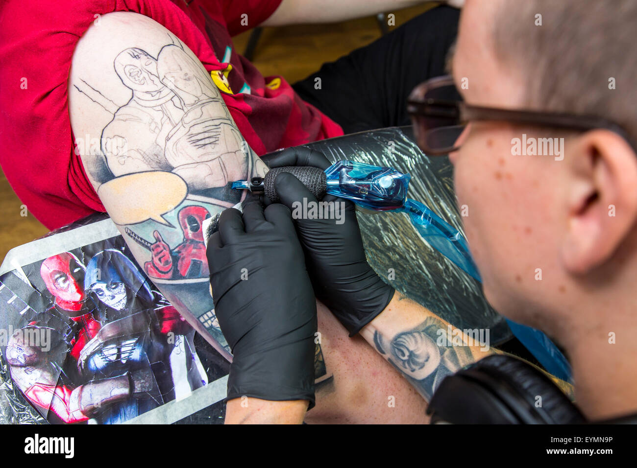 Tattoo studio, tattoo artist at work, tattooing with a machine, needle ...