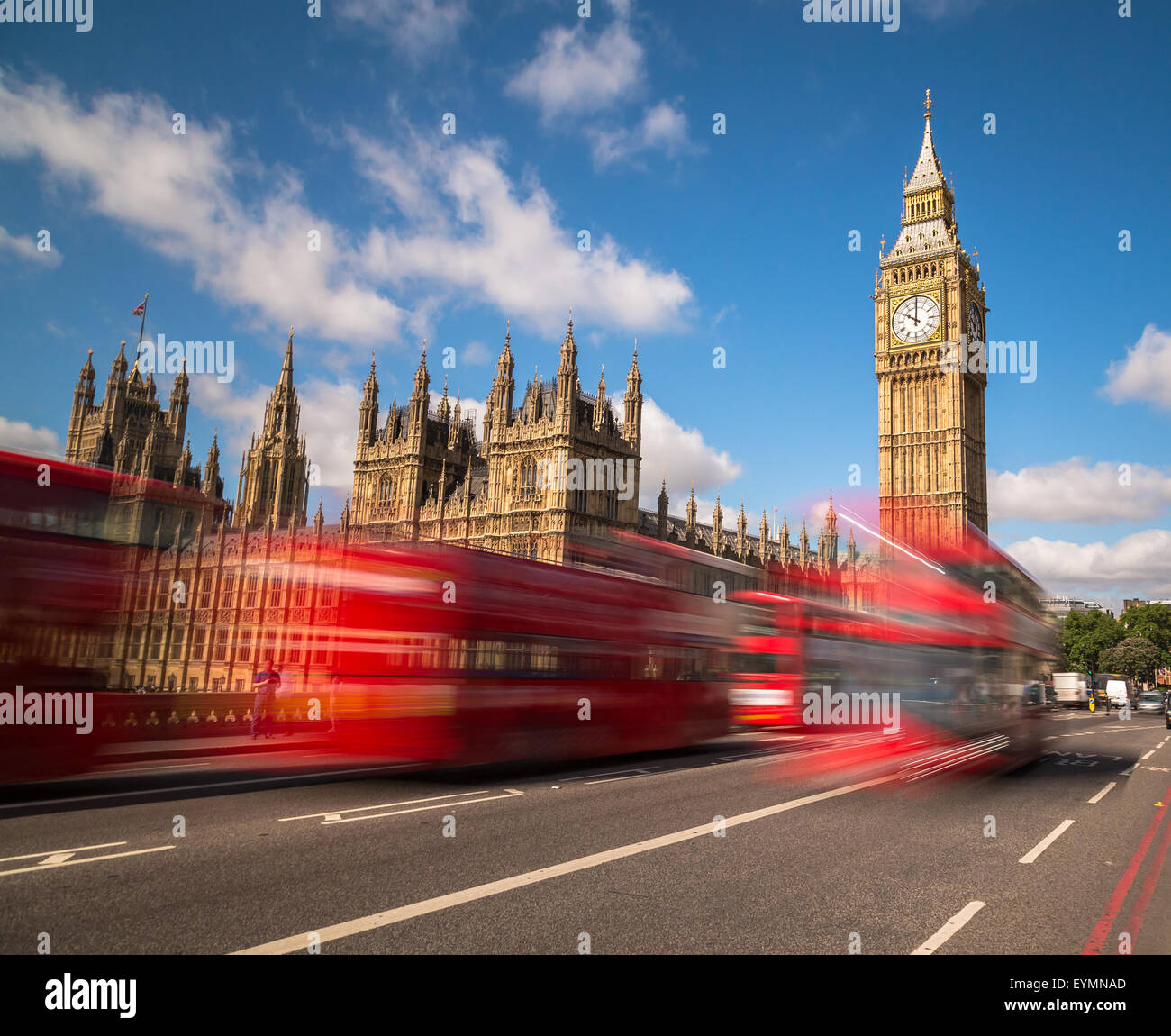 Big Ben in Westminster with red London Buses going past during the day ...