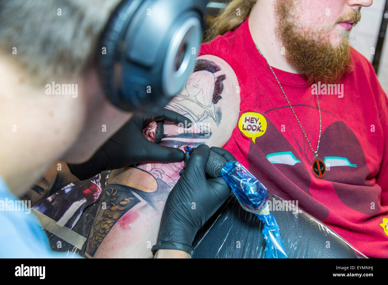 Tattoo studio, tattoo artist at work, tattooing with a machine, needle ...