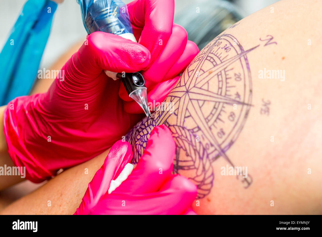 Tattoo studio, tattoo artist at work, tattooing with a machine, needle ...