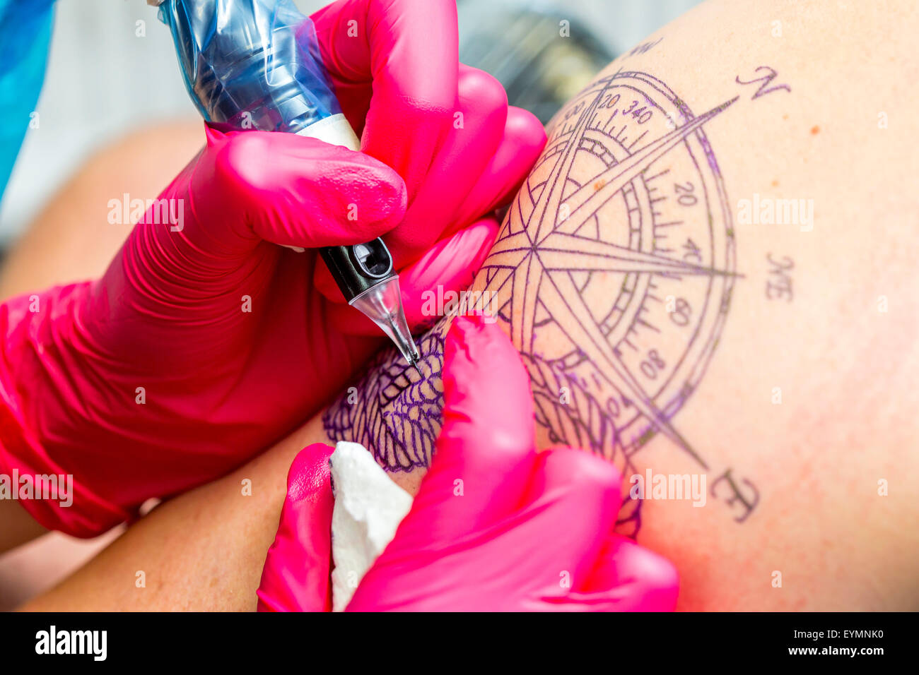Tattoo studio, tattoo artist at work, tattooing with a machine, needle ...
