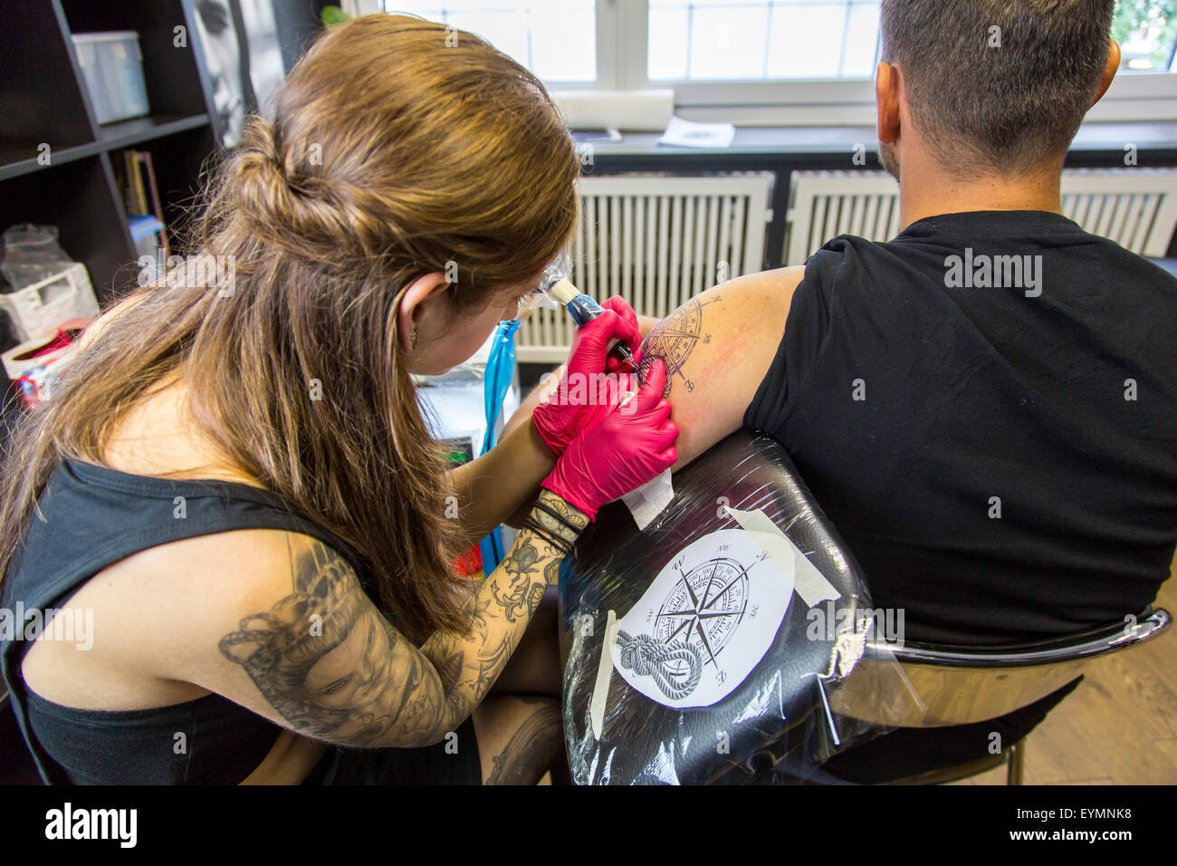 Tattoo studio, tattoo artist at work, tattooing with a machine, needle ...