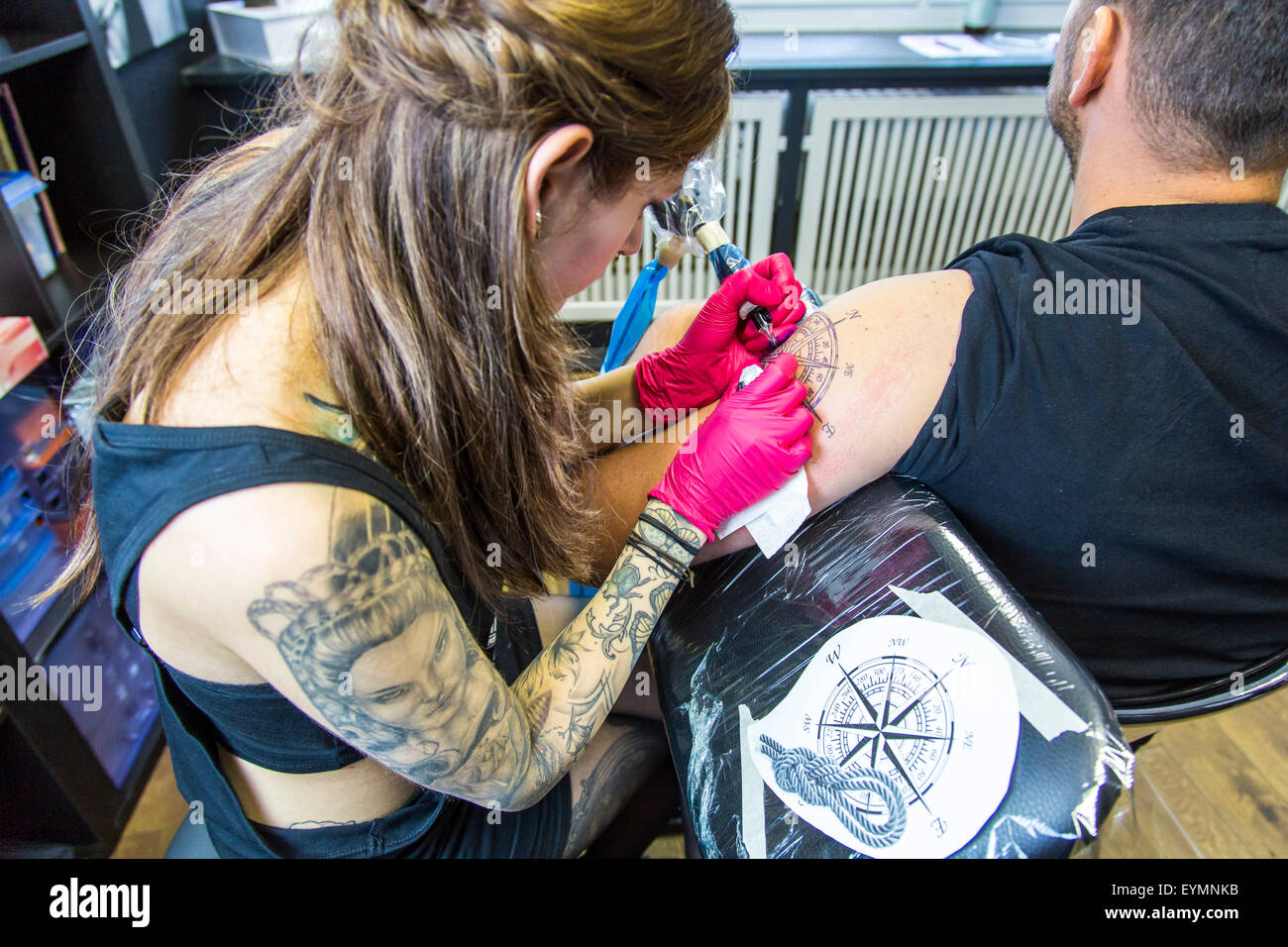 Tattoo studio, tattoo artist at work, tattooing with a machine, needle ...