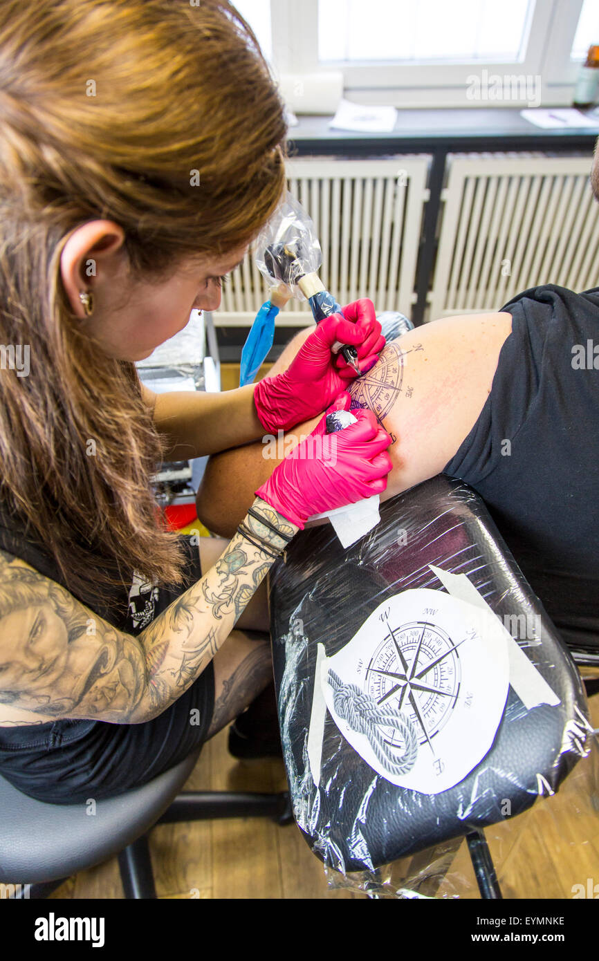 Tattoo studio, tattoo artist at work, tattooing with a machine, needle ...