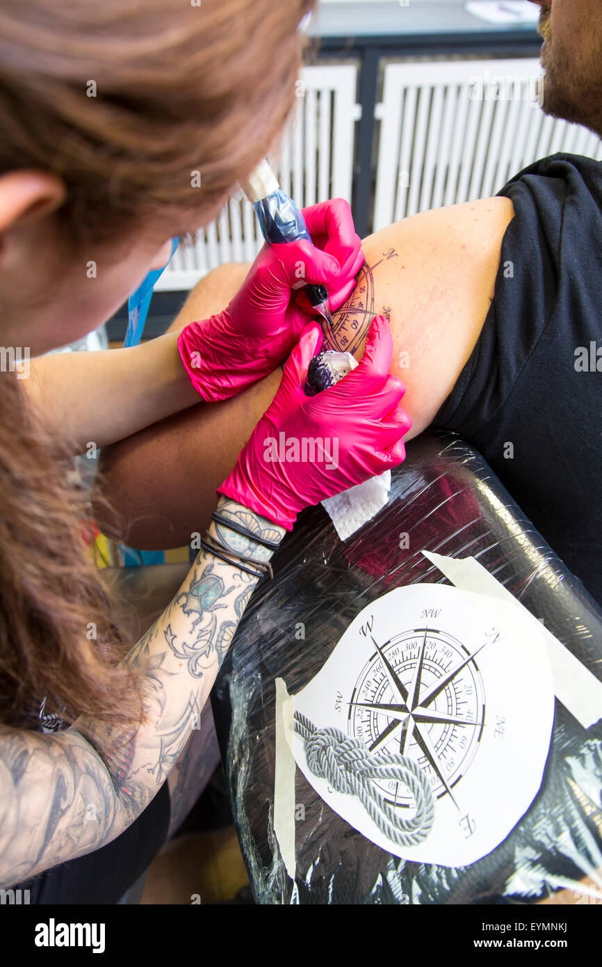 Tattoo studio, tattoo artist at work, tattooing with a machine, needle ...
