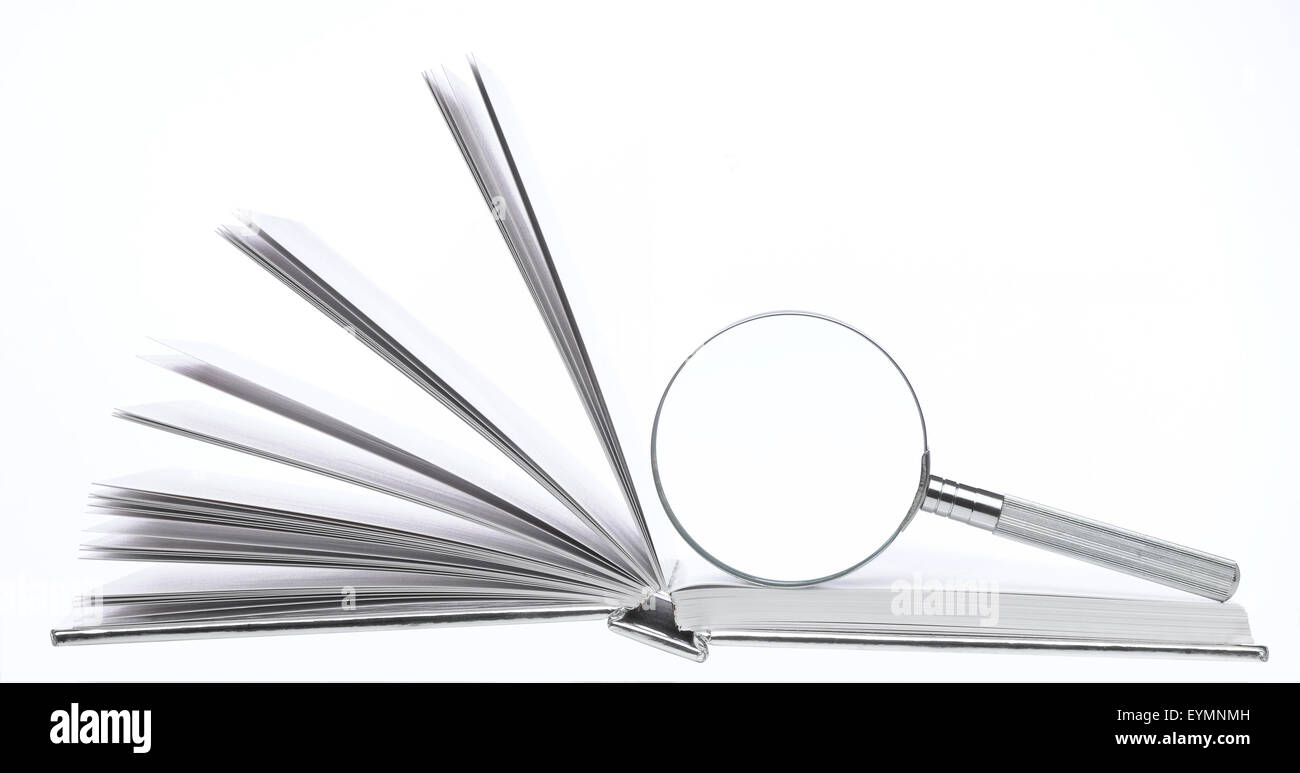Magnifying Glass on open book Stock Photo - Alamy