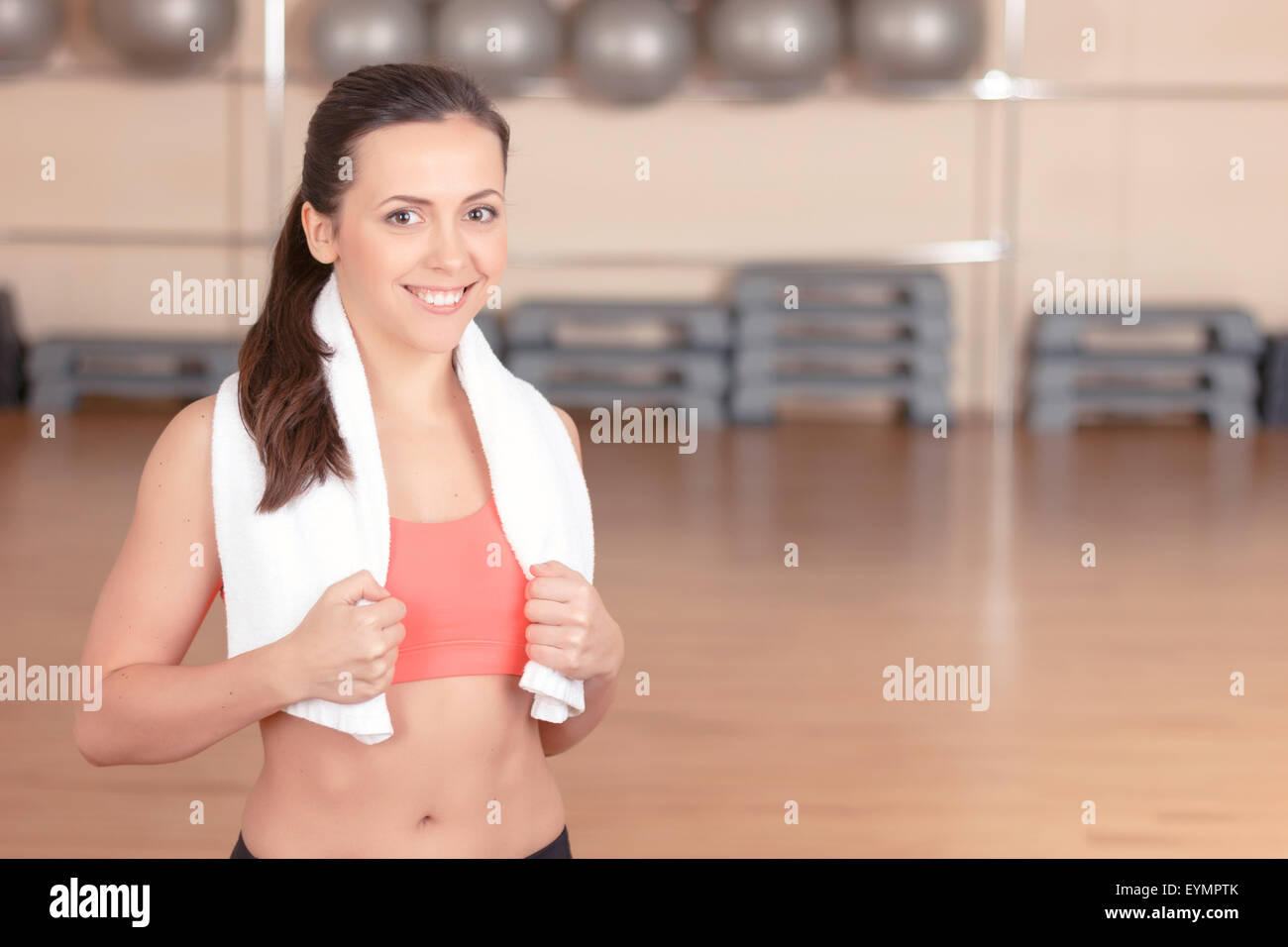Smiling woman with towel in gym Stock Photo - Alamy
