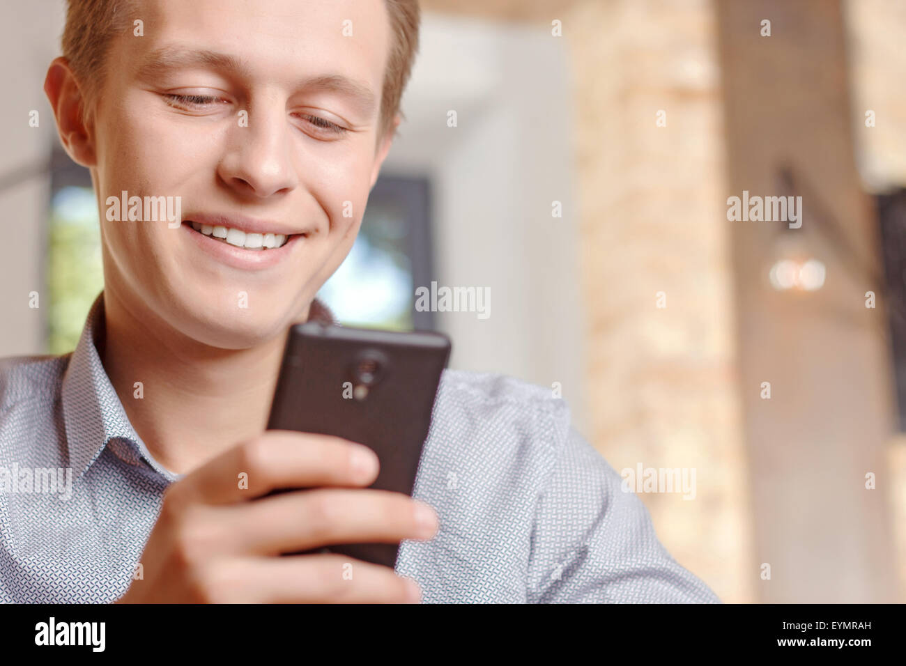 Handsome guy using mobile phone in cafe Stock Photo - Alamy