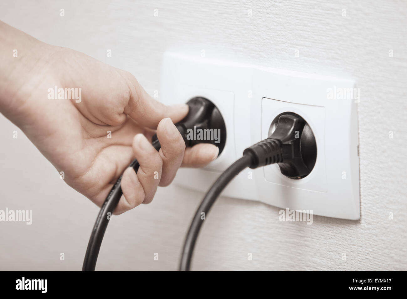 Woman plugging cable to the electric outlet Stock Photo - Alamy