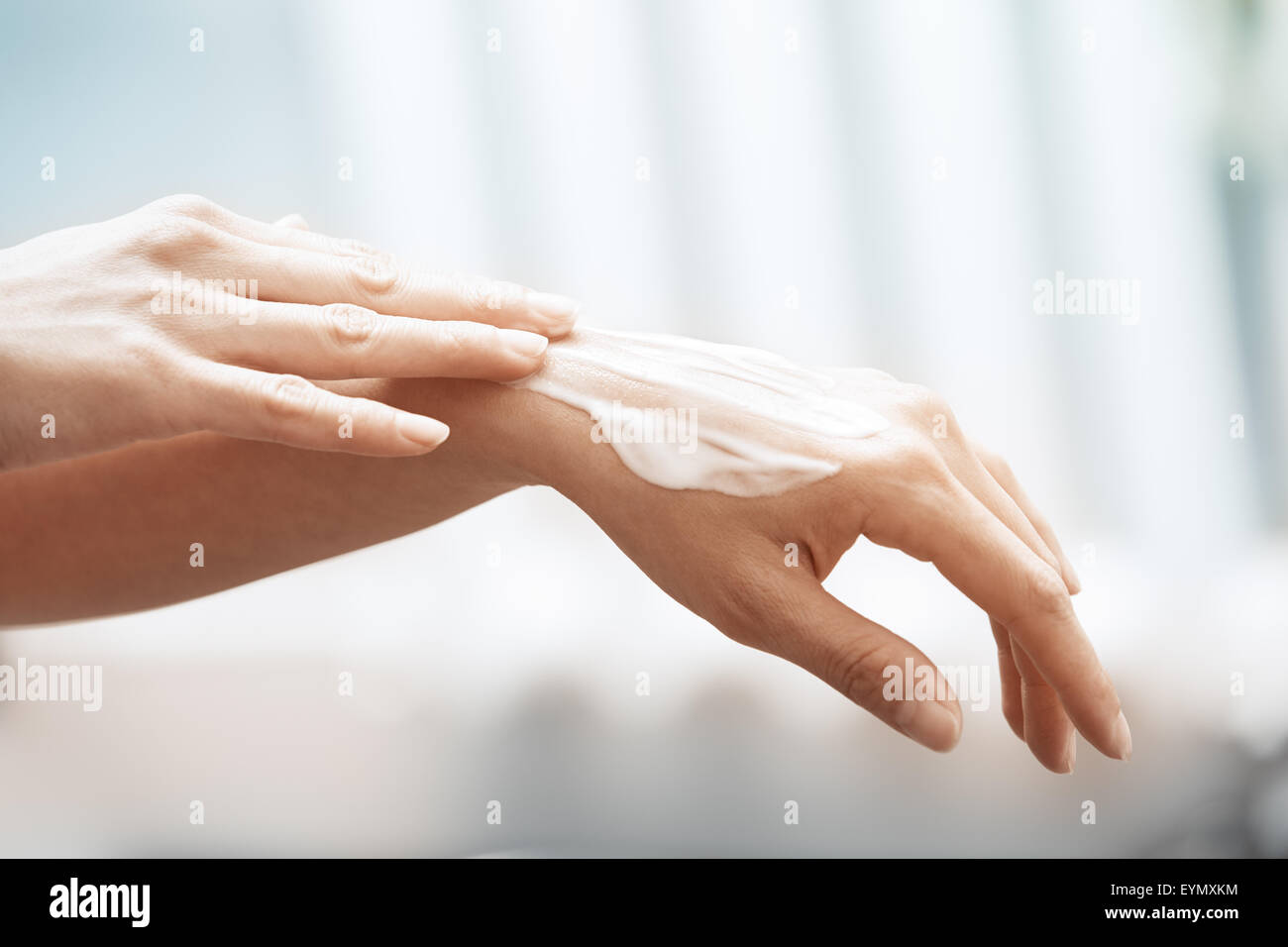 Woman applying moisturizing cream on hands Stock Photo - Alamy