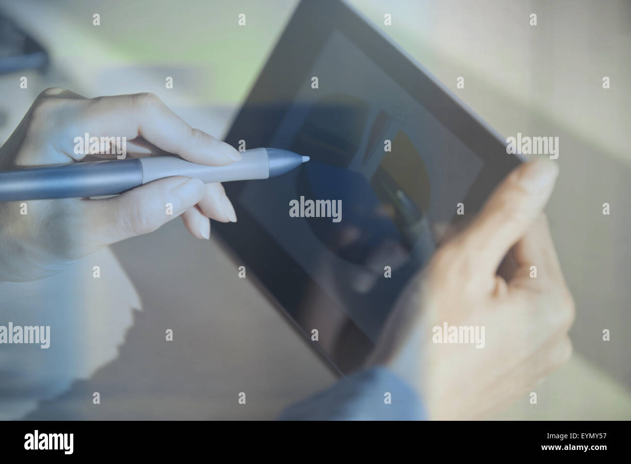 Human hands with digital tablet and stylus drawing graph behind the ...