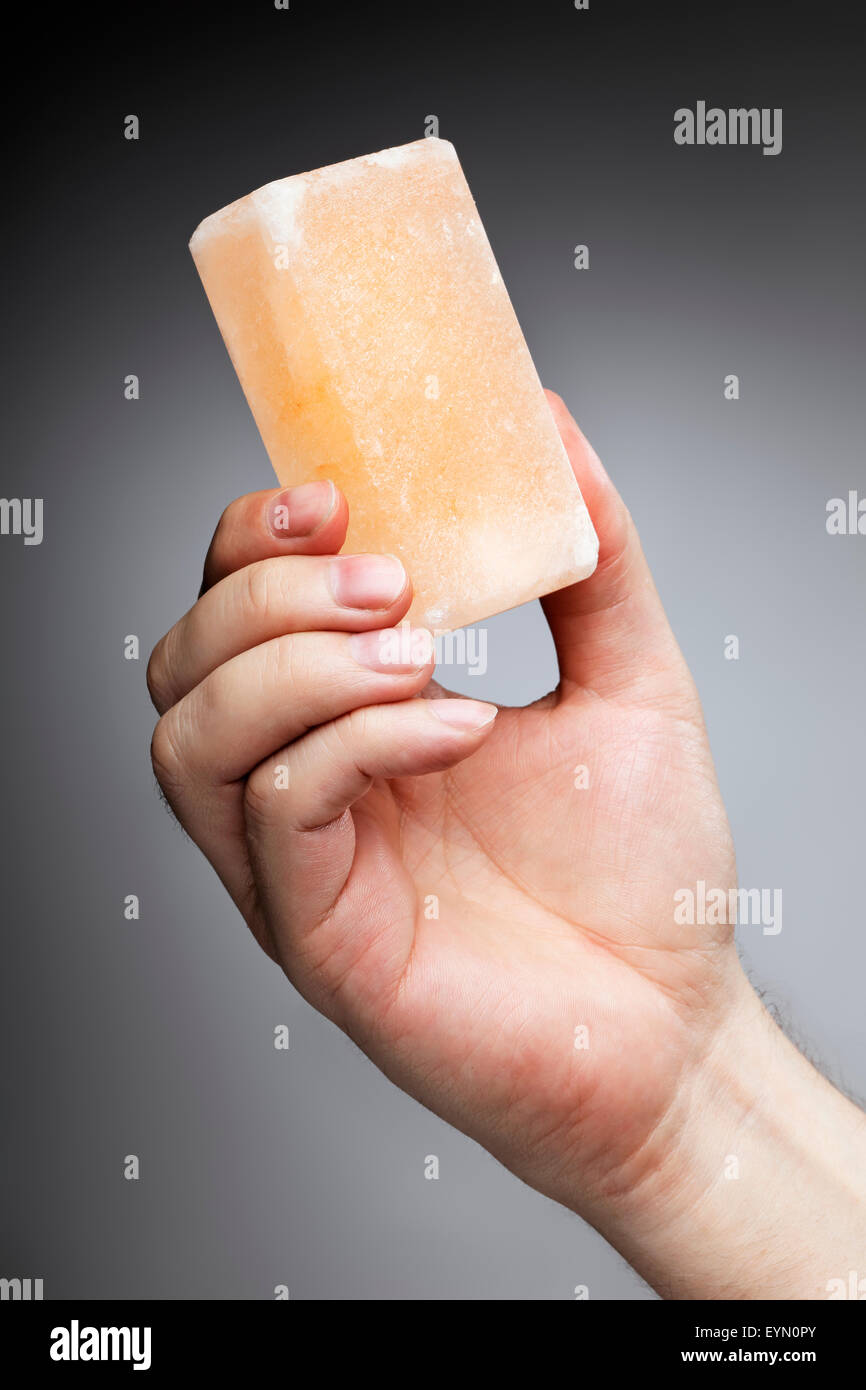 Man holding a himalayan salt soap bar, used for cleansing the skin or ...