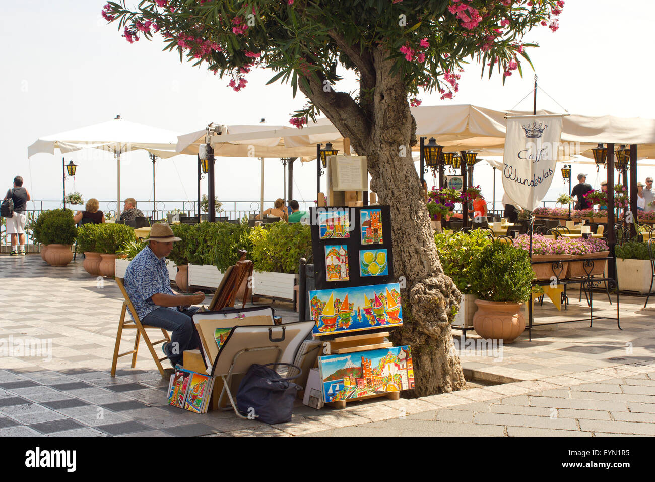 Street painter painting under the shade of a tree in Sicily, Italy ...