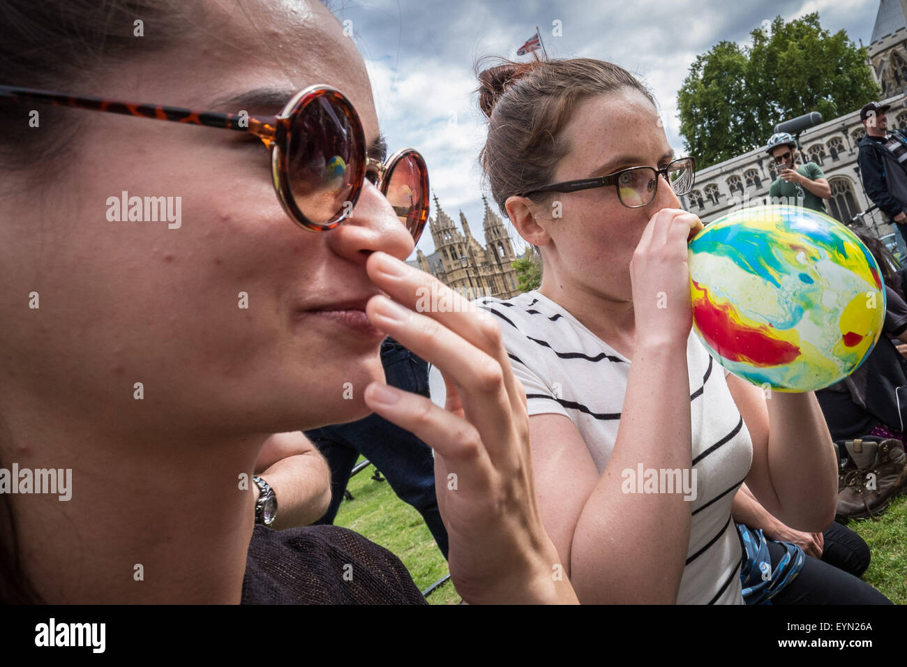 London, UK. 1st August, 2015. Campaigners inhale balloons inflated with ...