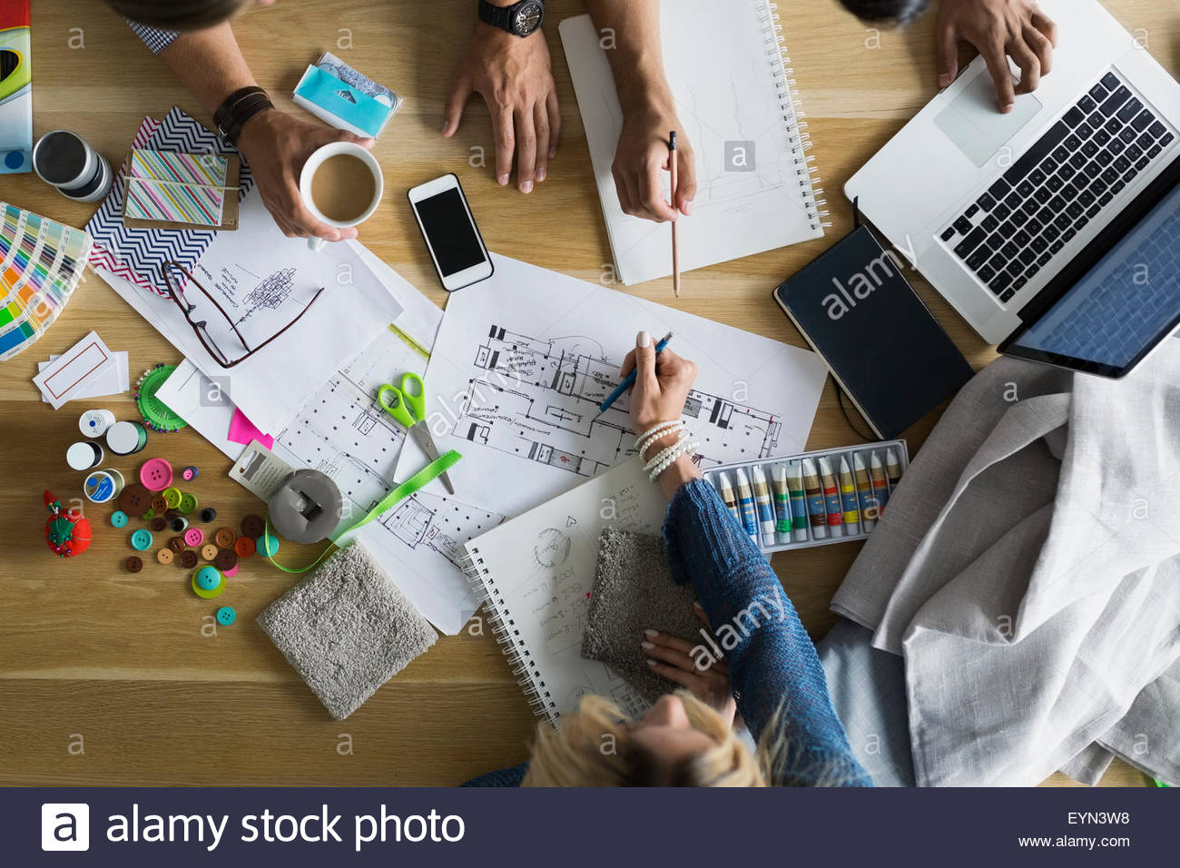Overhead view of architects and designers reviewing blueprints Stock ...