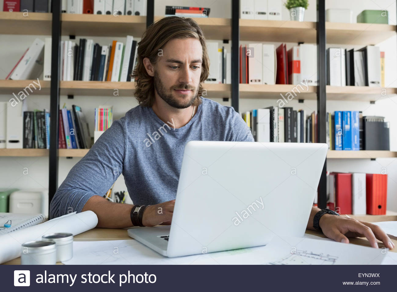 Architect using laptop over blueprints Stock Photo - Alamy