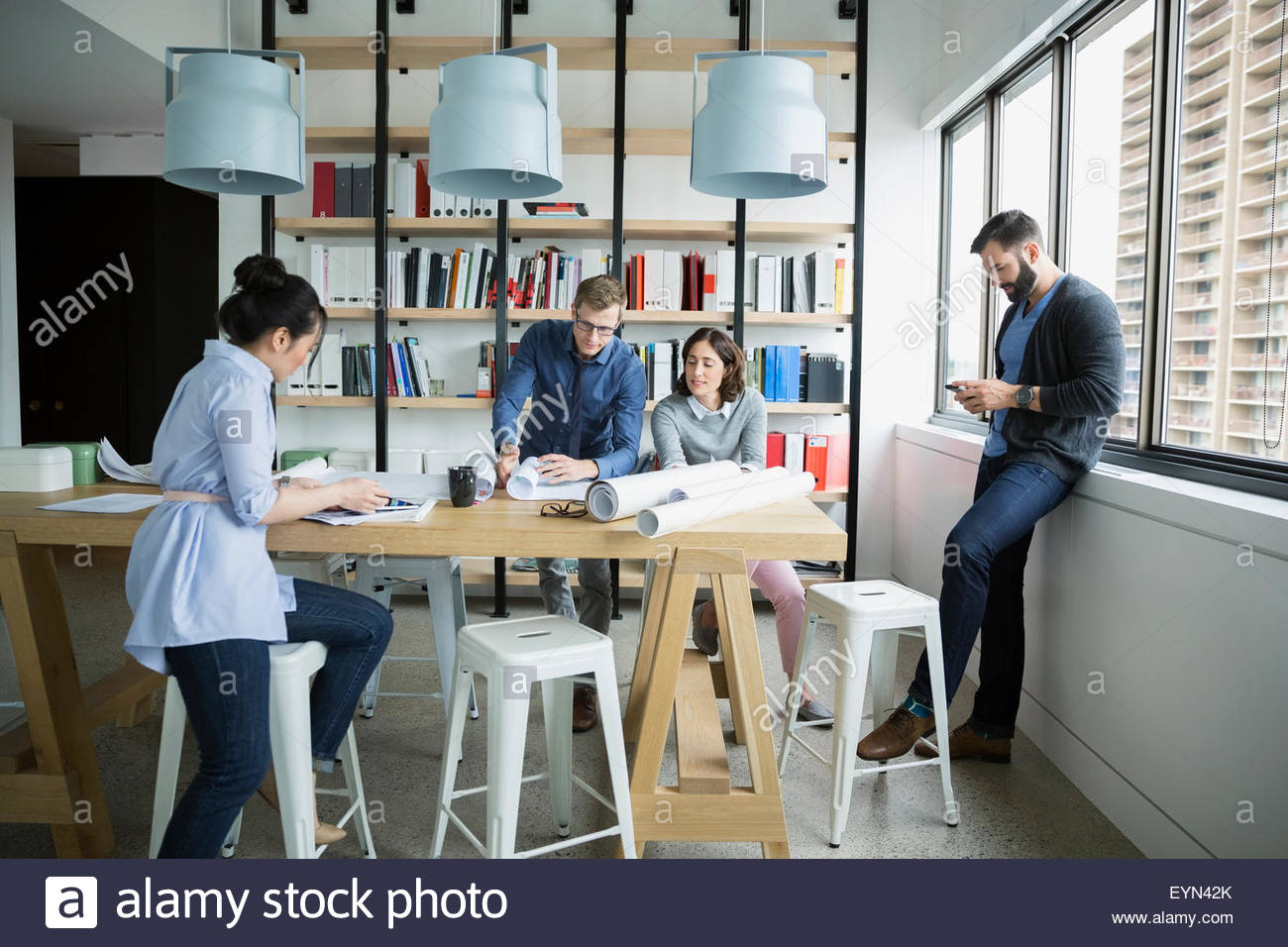 Architects meeting and reviewing blueprints in office Stock Photo - Alamy