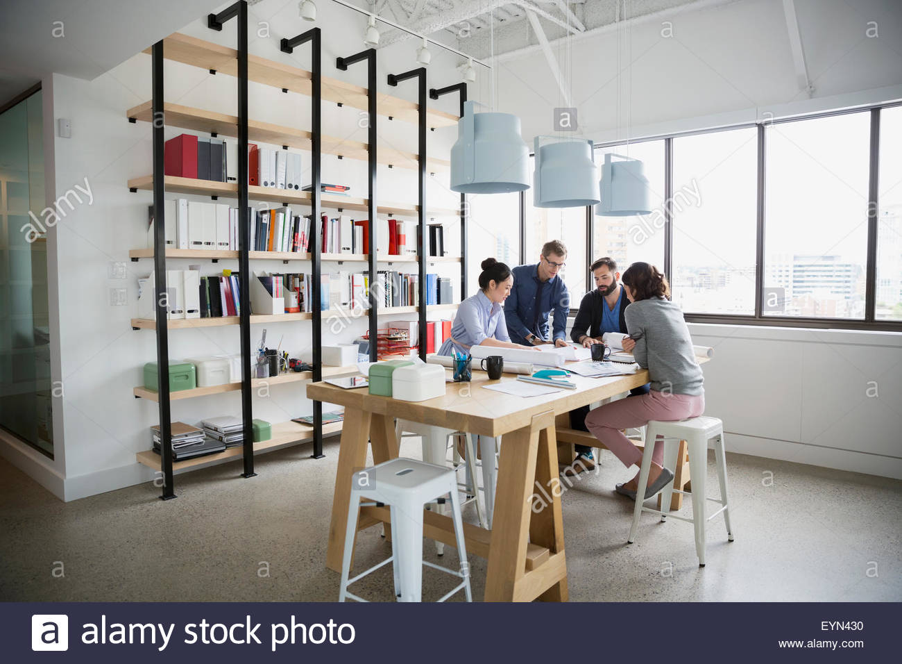 Architects meeting and reviewing blueprints in office Stock Photo - Alamy