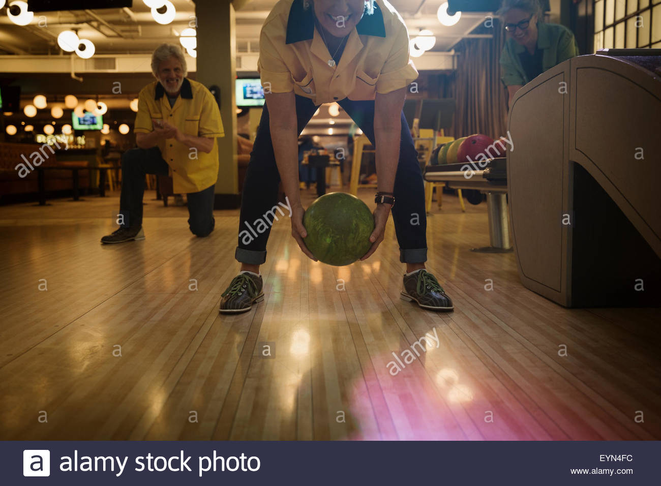 Woman bowling between legs at bowling alley Stock Photo - Alamy