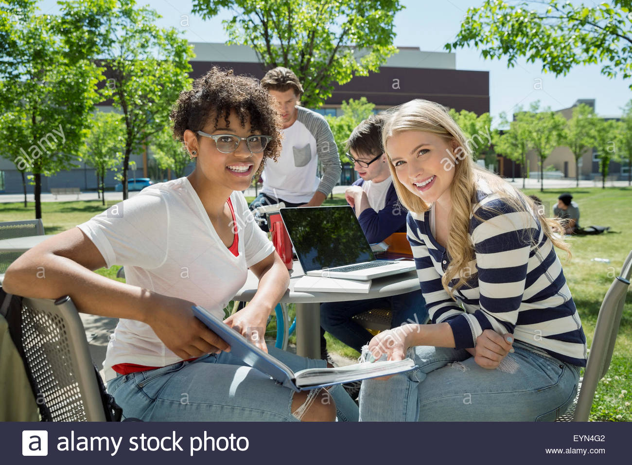 Portrait confident college students studying on sunny campus Stock ...