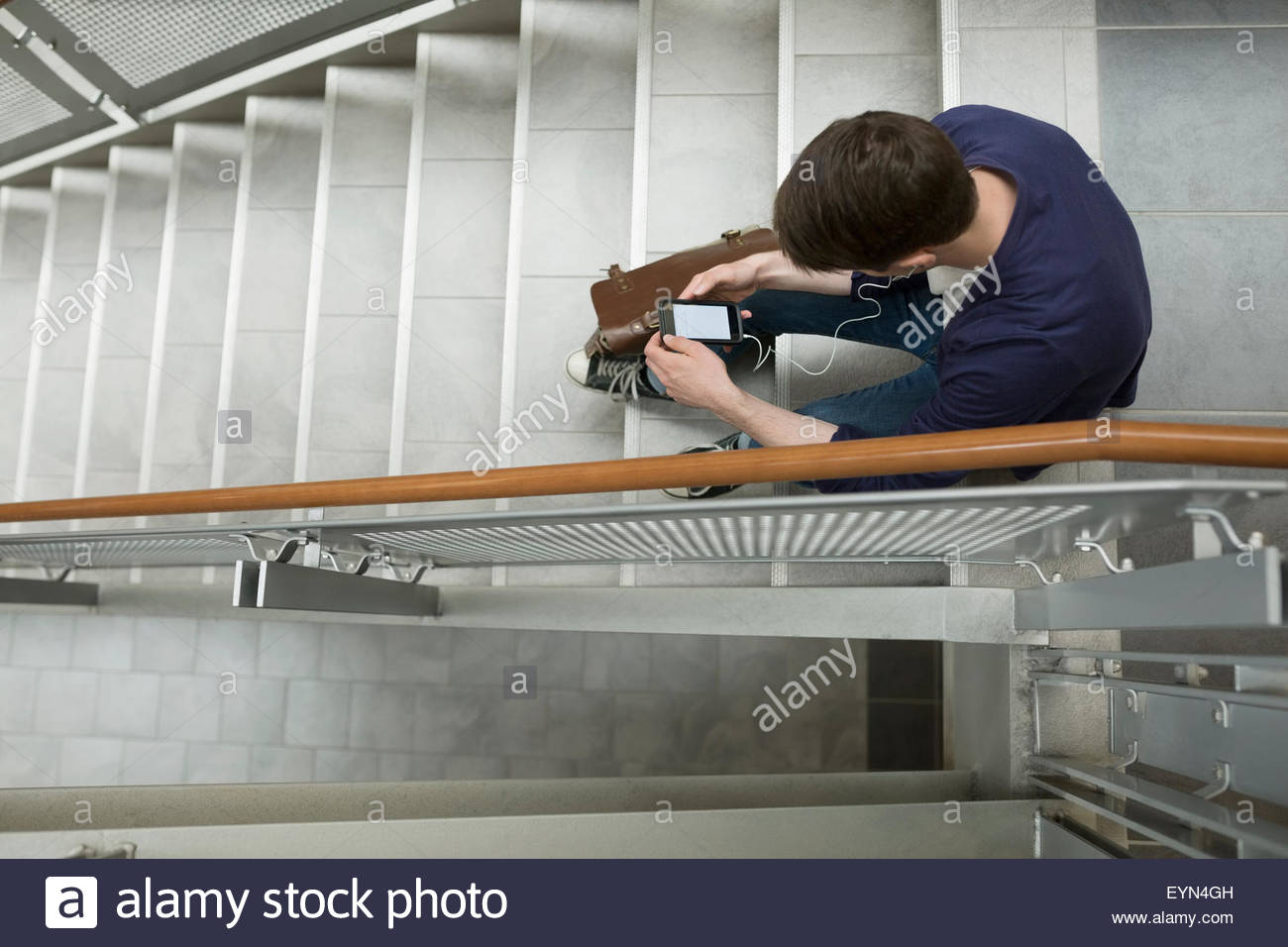 College student using mp3 player on stairs Stock Photo - Alamy