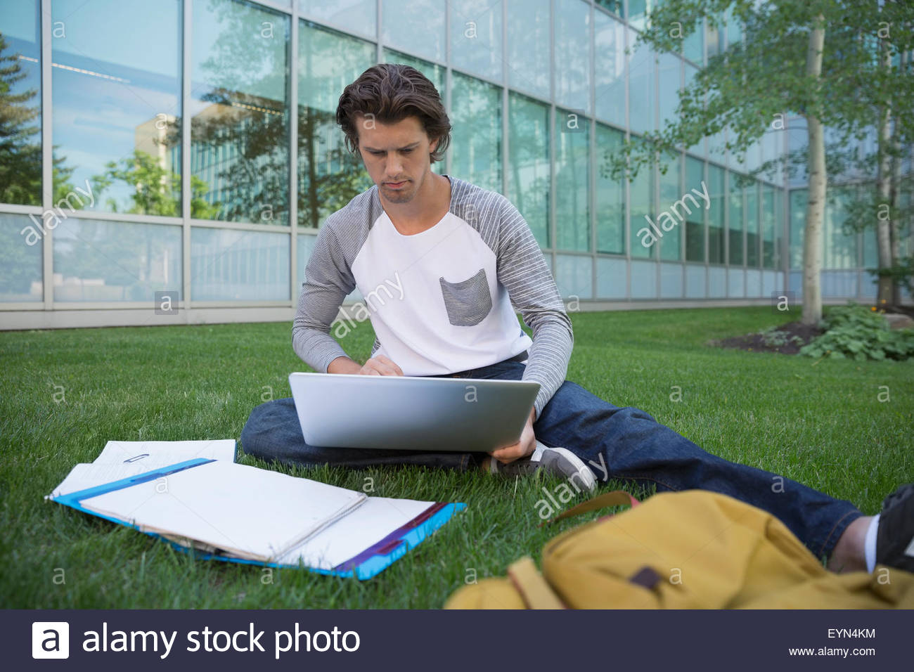 College student with laptop studying on campus lawn Stock Photo - Alamy