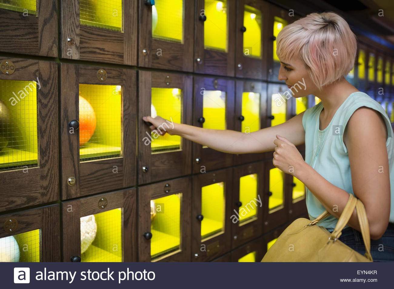 Young woman opening bowling ball locker Stock Photo - Alamy