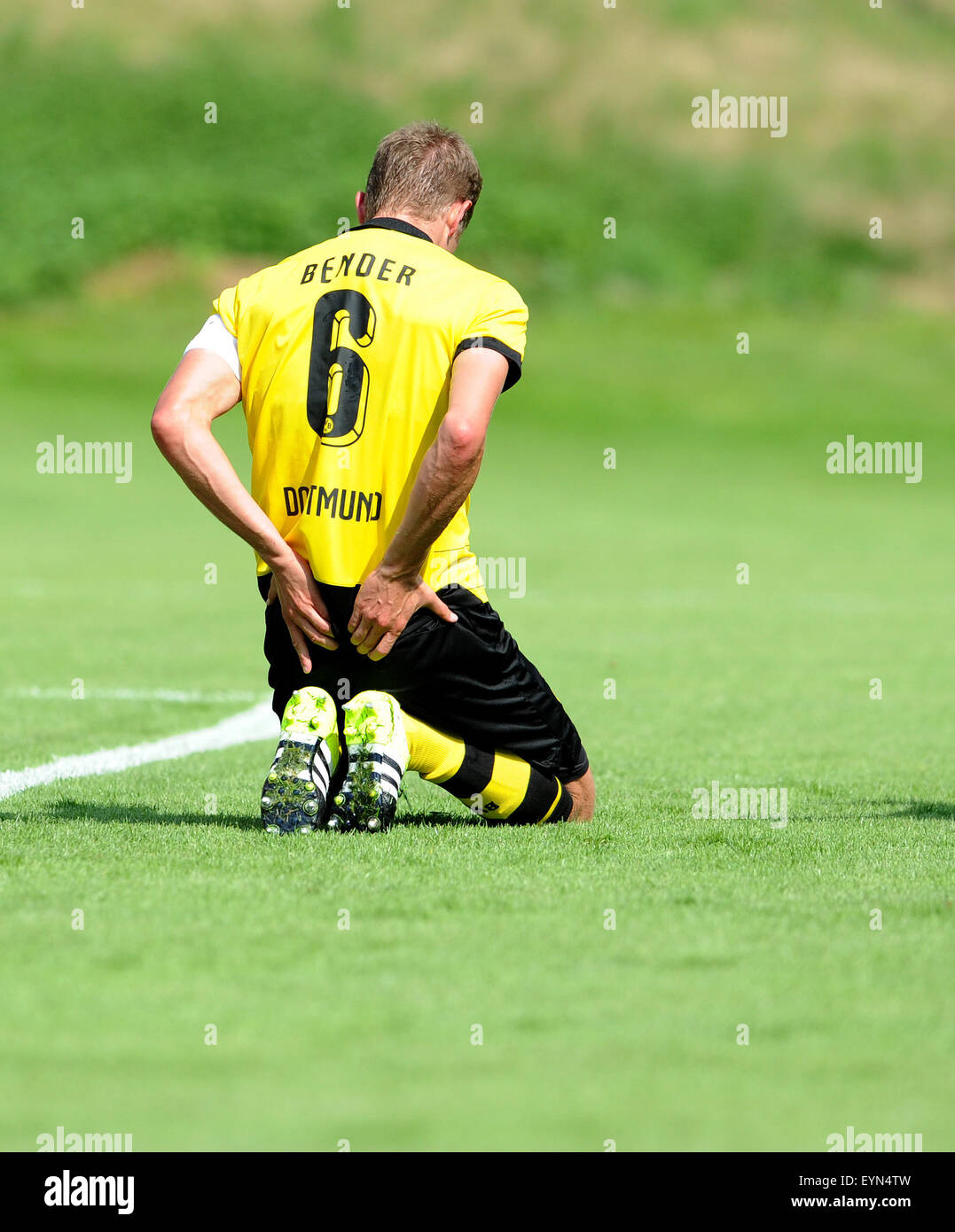 Dortmund's Sven Bender holds his back after a fall during the soccer ...