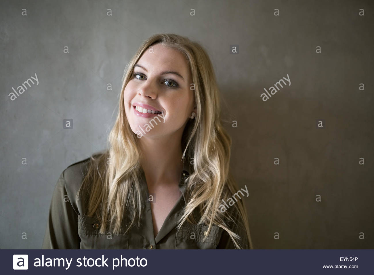Portrait smiling blonde businesswoman against gray background Stock ...