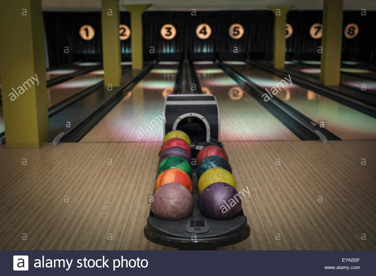 Multicolor bowling balls on rack at bowling alley Stock Photo - Alamy