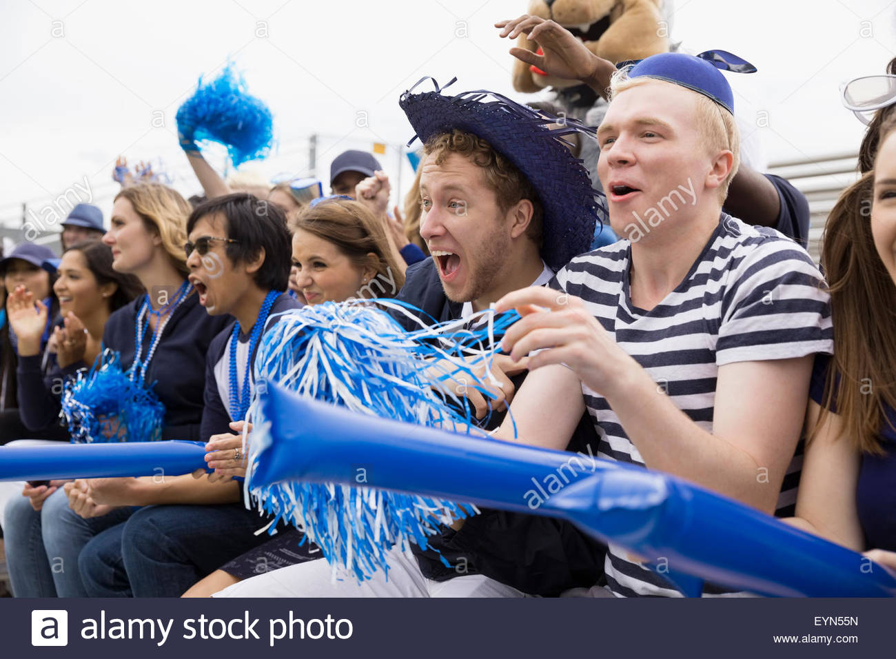 Enthusiastic fans in blue cheering bleachers sports event Stock Photo ...