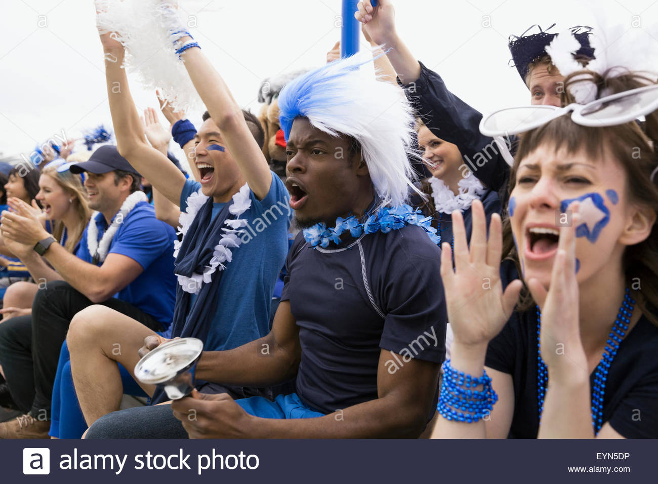 Enthusiastic fans in blue cheering bleachers sports event Stock Photo ...