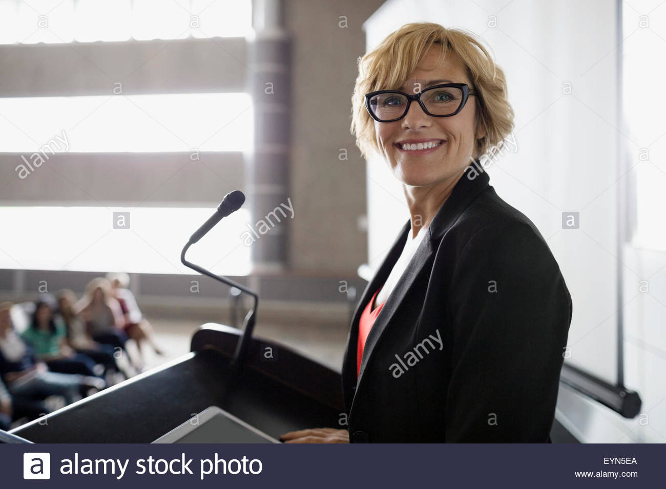 Portrait confident professor at podium in auditorium Stock Photo - Alamy