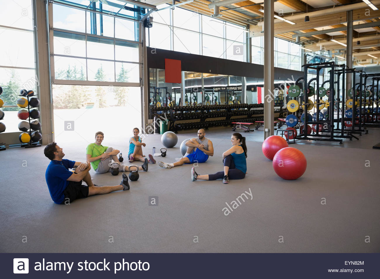 Exercise class stretching in seated twist at gym Stock Photo - Alamy