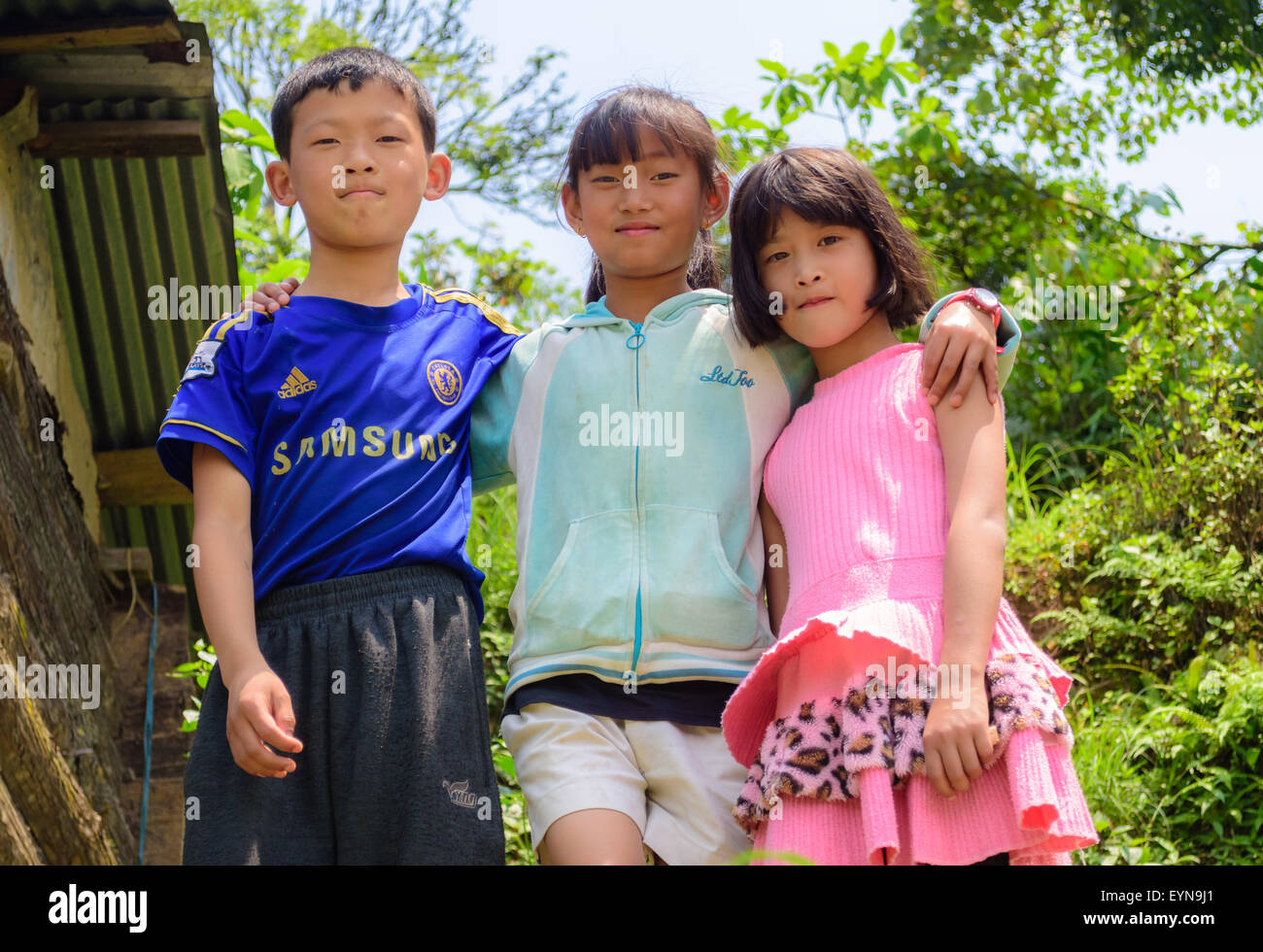 Three young children standing together with copy space Stock Photo - Alamy