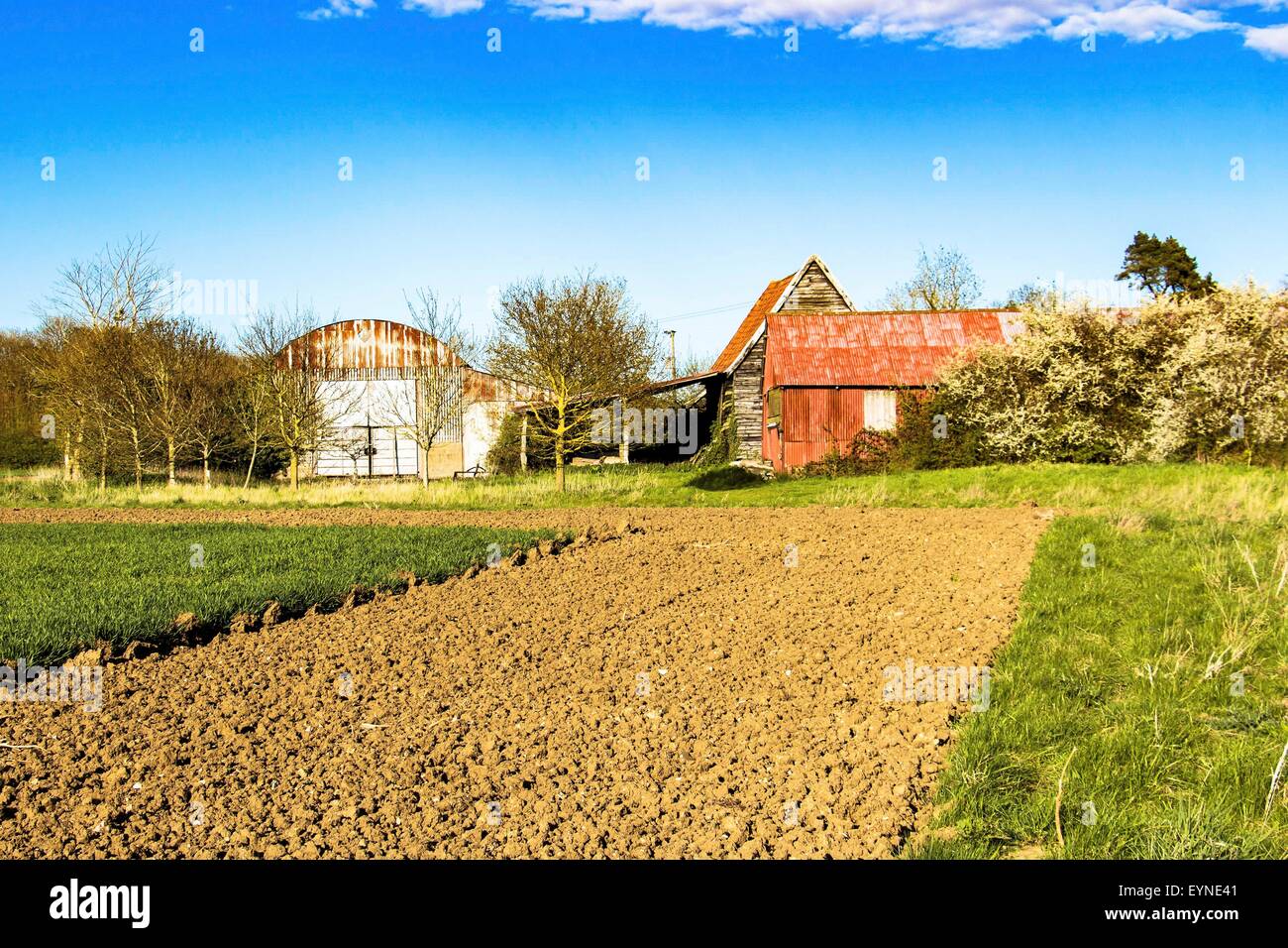 Abandoned old barns and sheds next to a ploughed field Stock Photo - Alamy