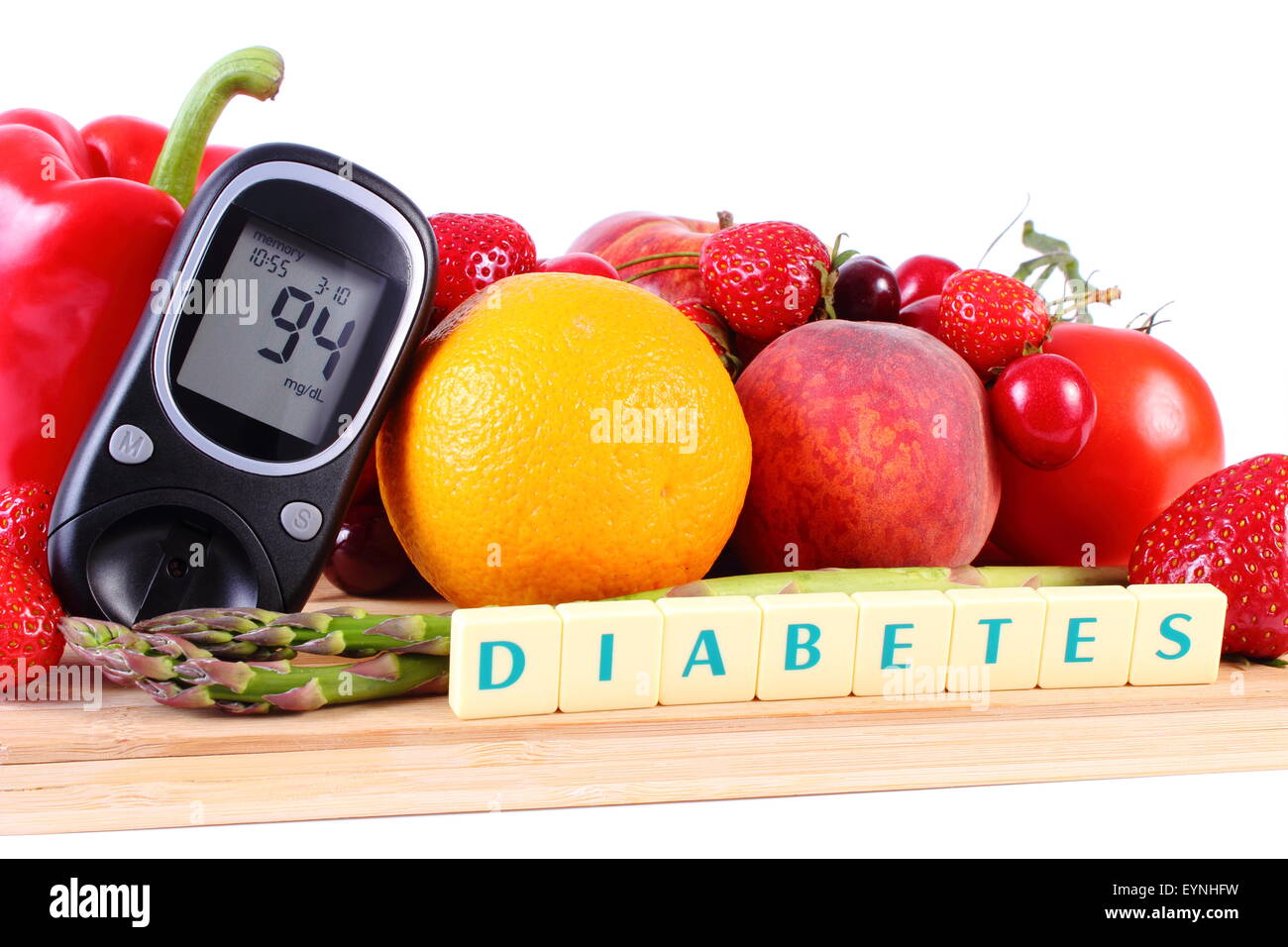 Glucose meter with fresh ripe fruits and vegetables on wooden cutting ...