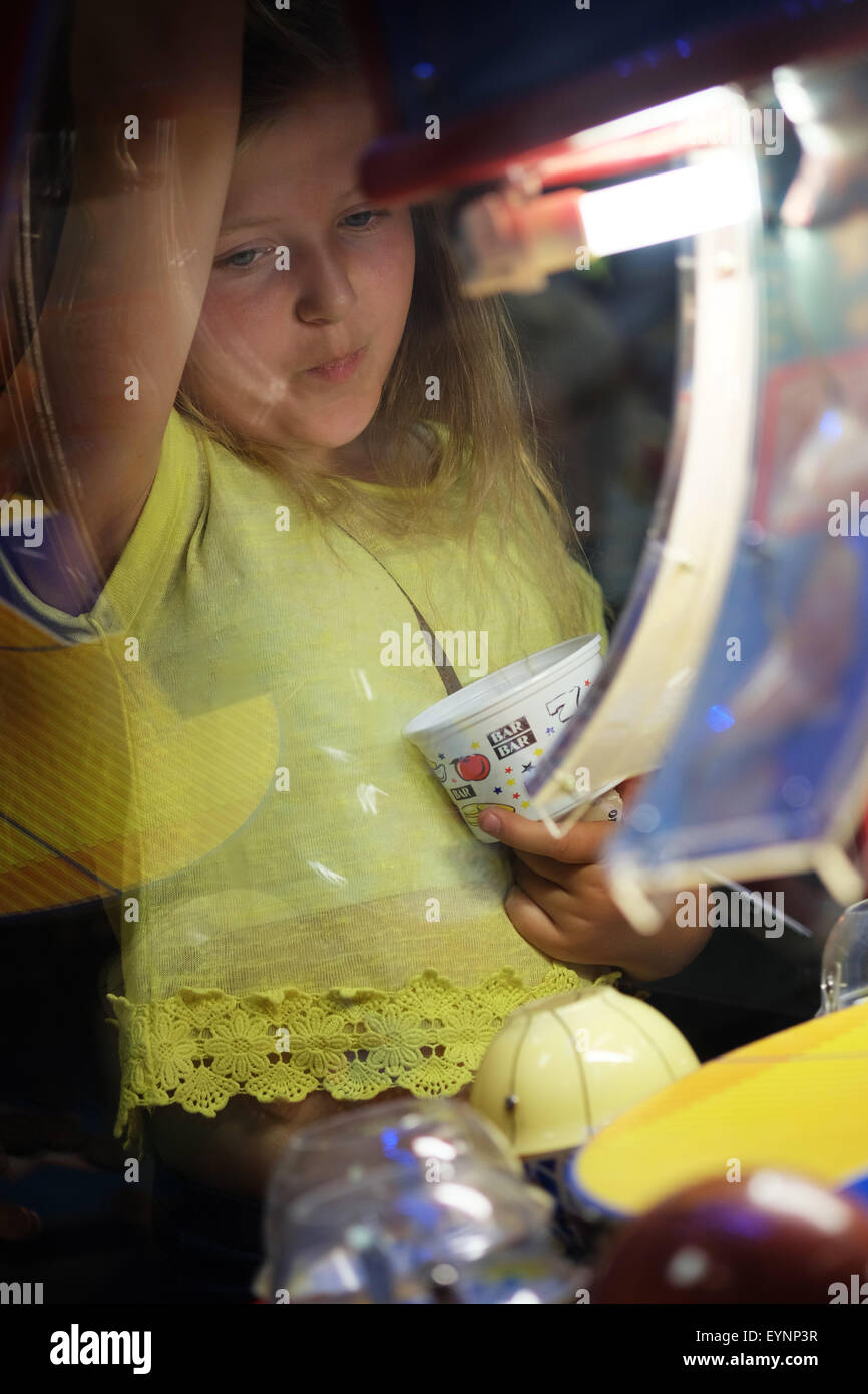 Girl playing two pence amusement arcade machine Stock Photo - Alamy