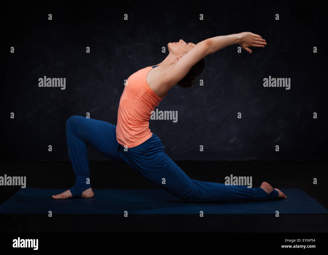 Fit yogini woman practices yoga asana Anjaneyasana Stock Photo - Alamy