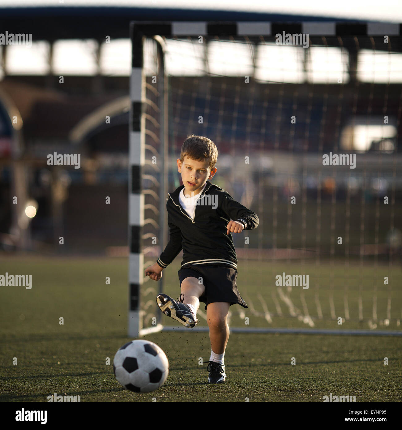 boy plays football on stadium Stock Photo - Alamy