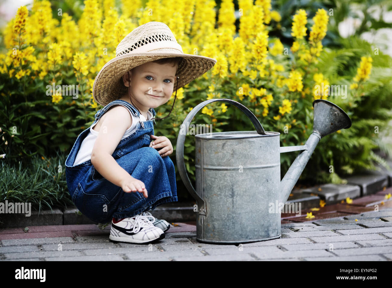 little boy with watering can in summer park Stock Photo - Alamy