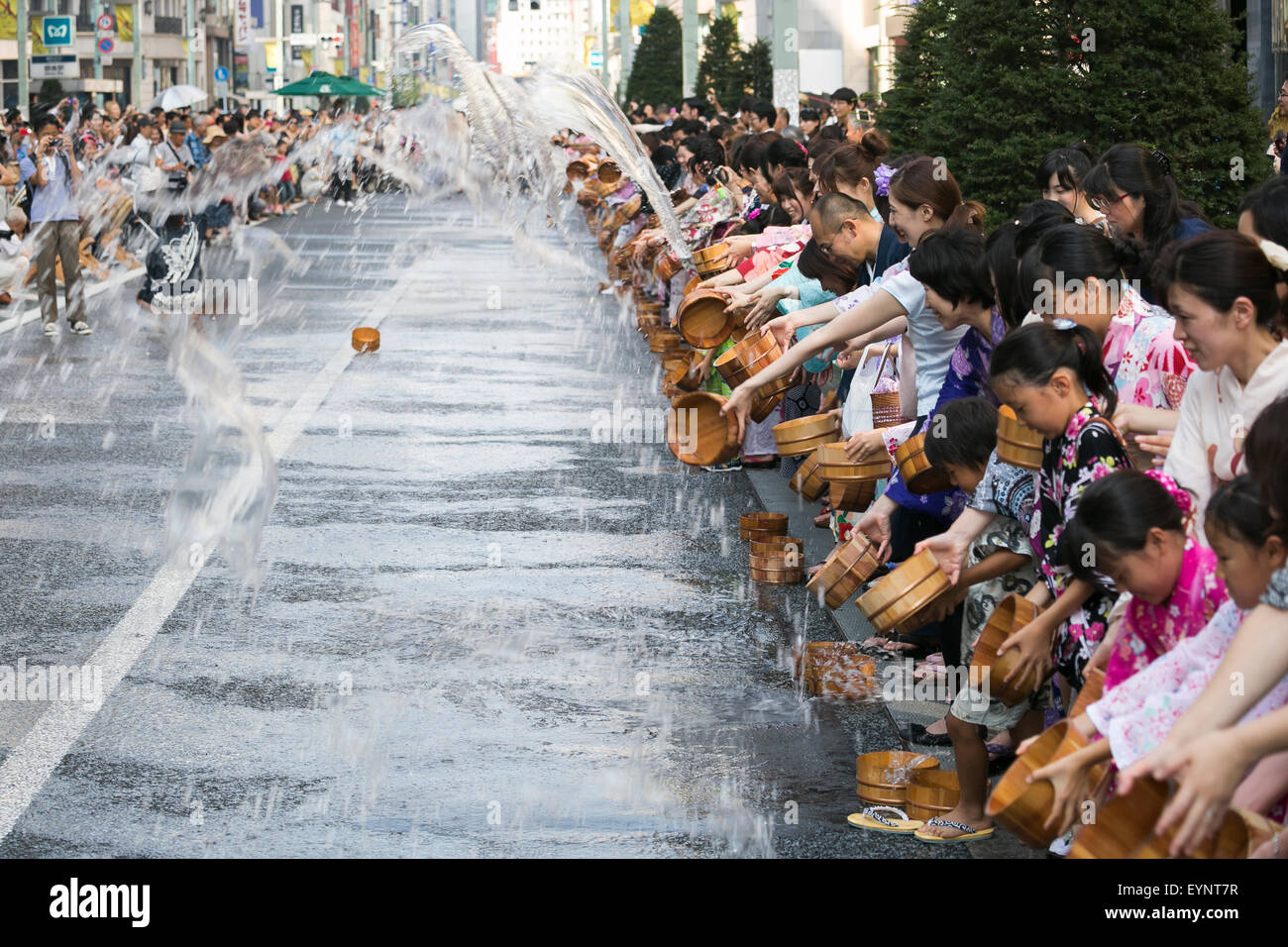 People wearing traditional Japanese Yukata sprinkle water onto the ...