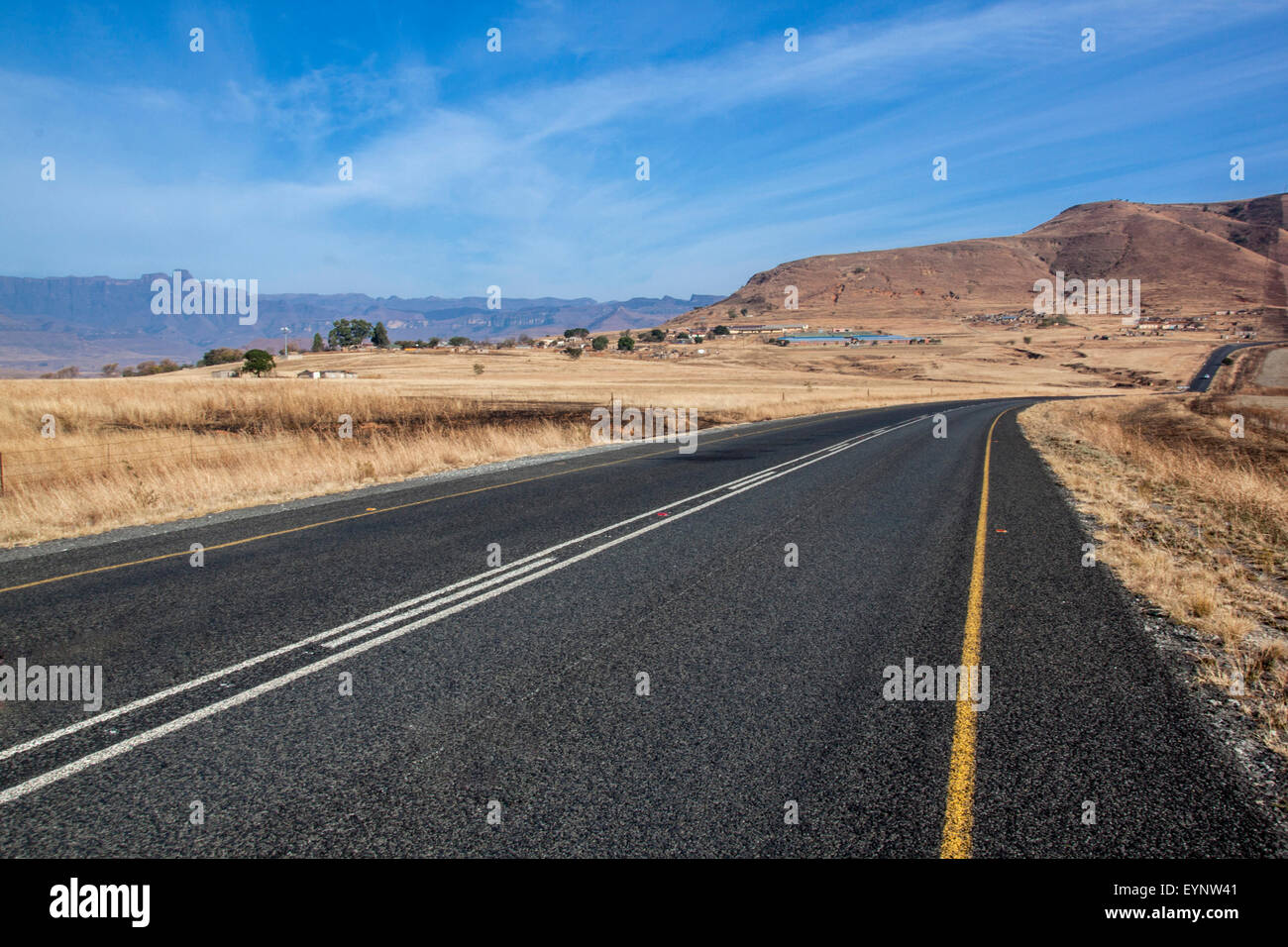 Straight empty asphalt country road road bordered with dry grass in ...