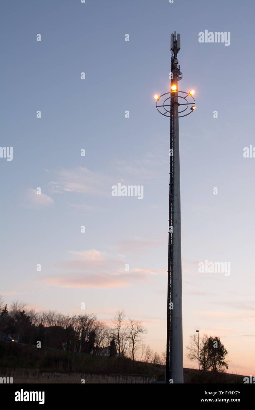 Pole with repeater for cell phone at night Stock Photo - Alamy