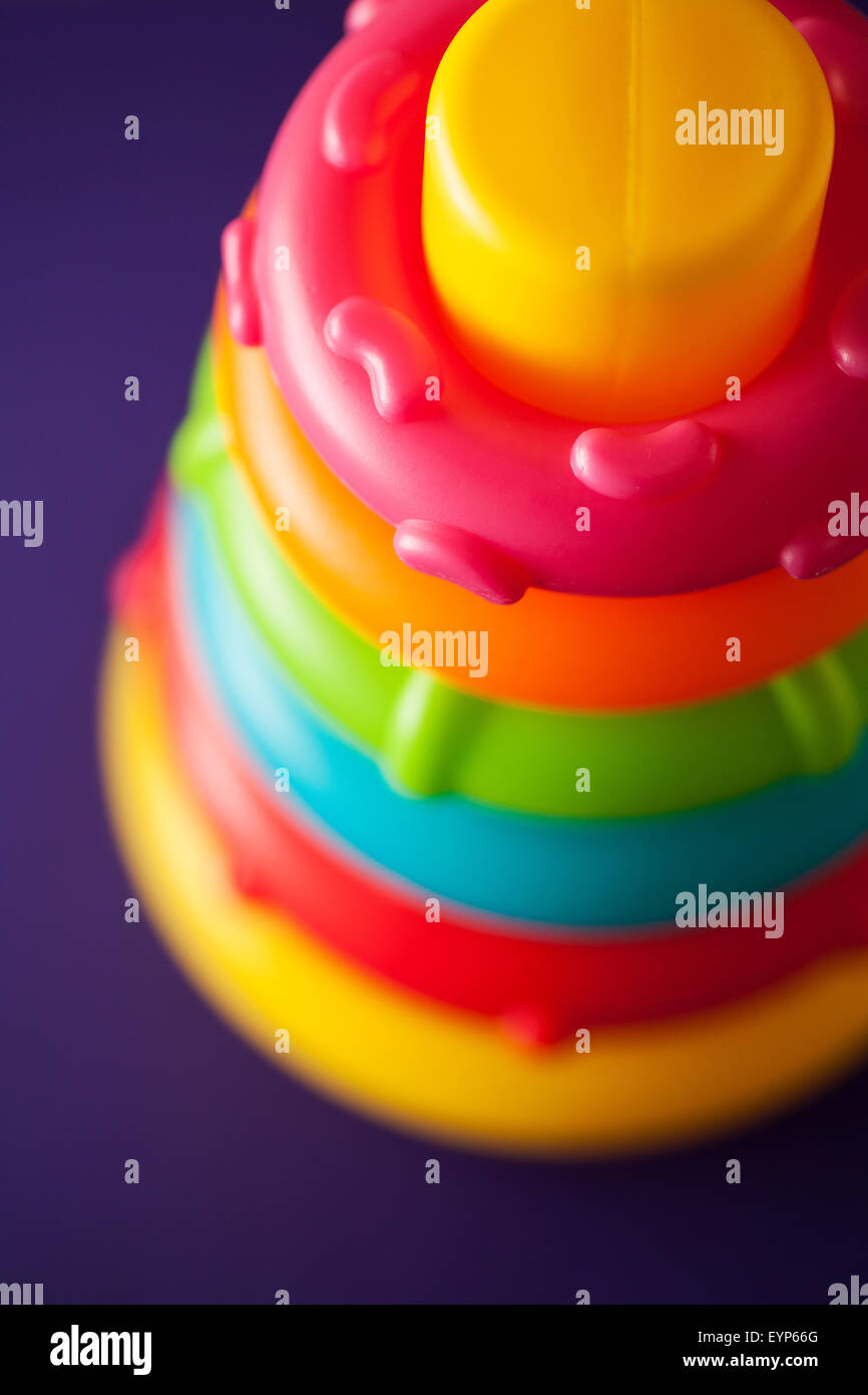 Child's stacking rings toy shot on a purple background. Multi coloured ...