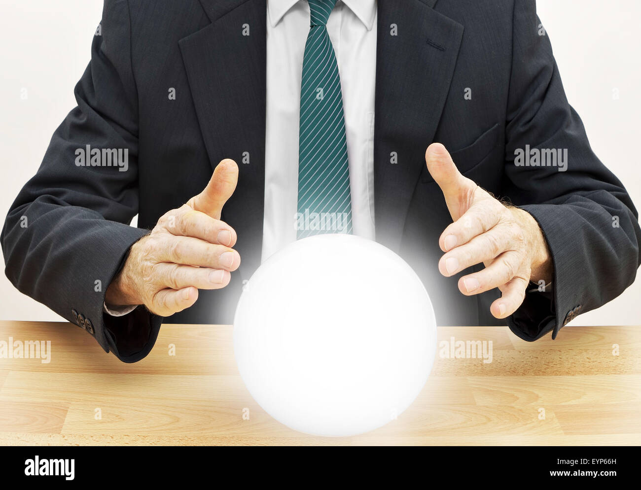 Man at desk trying to predict future with crystal ball Stock Photo - Alamy